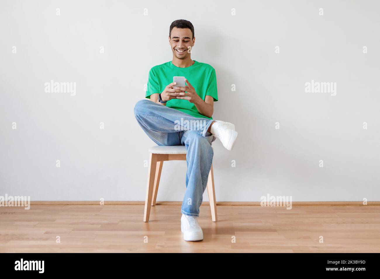 Excited young arab man using cellphone and texting or networking in ...