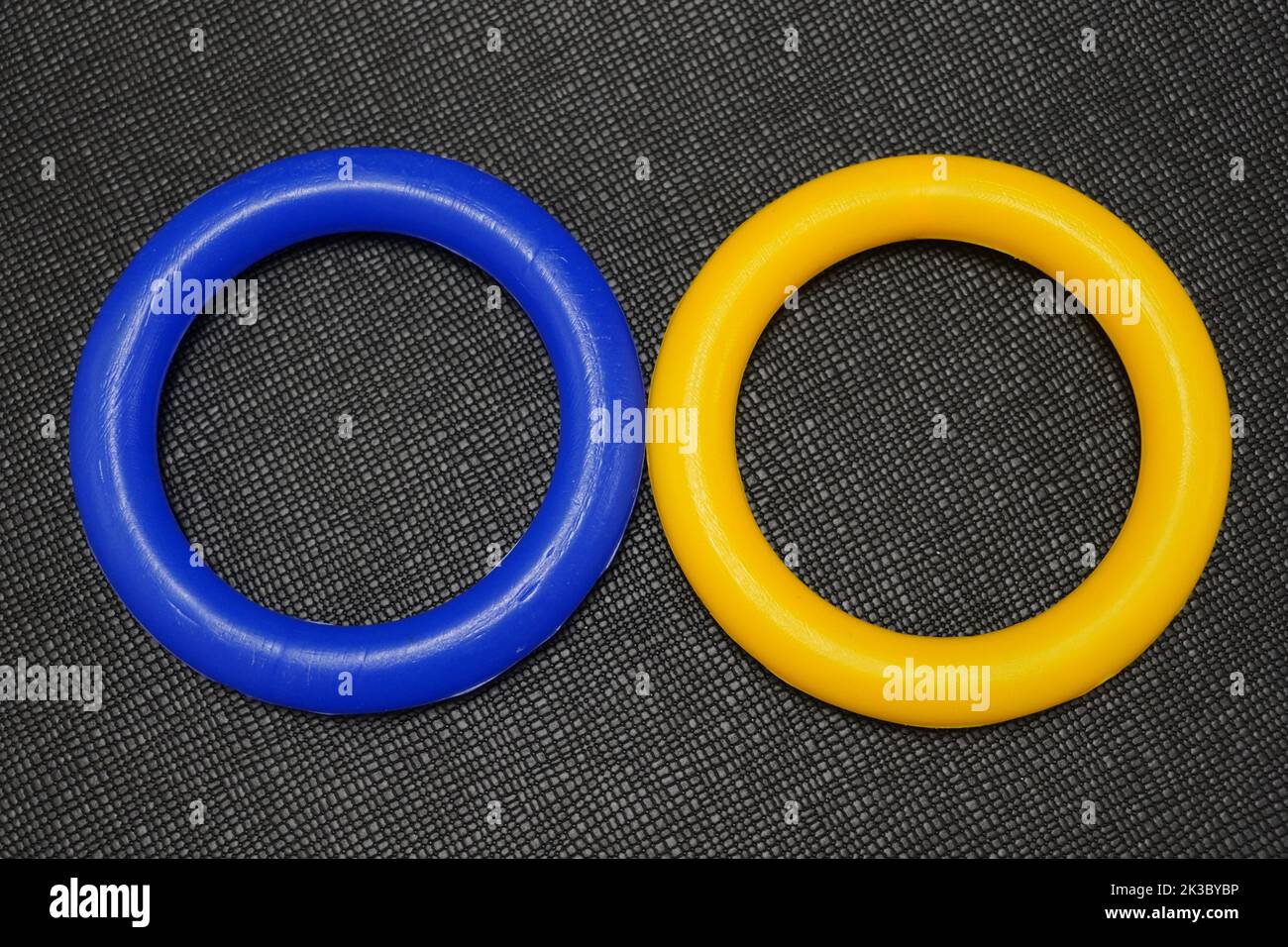 Concept with yellow toy rings in front of black background. Colored ...
