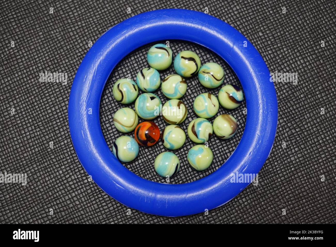 Colorful toy beads in the middle of the blue and yellow plastic ring on ...