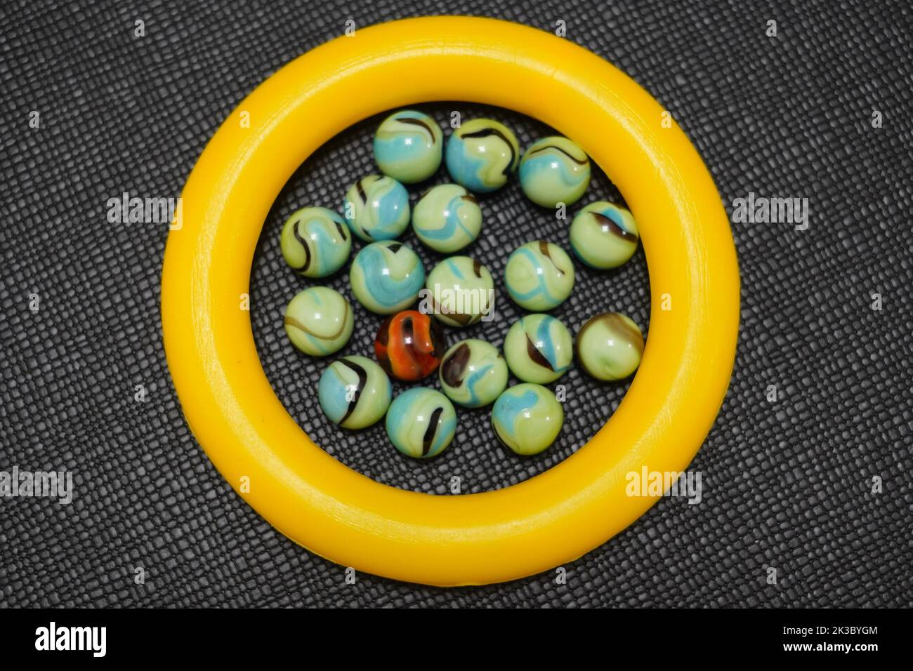 Colorful toy beads in the middle of the blue and yellow plastic ring on ...