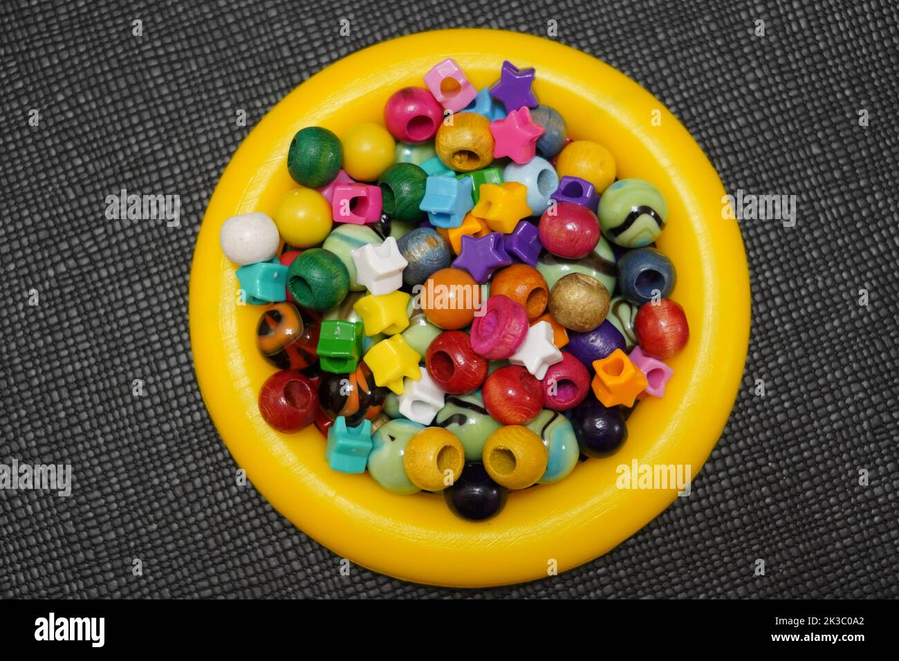 Colorful toy beads in the middle of the blue and yellow plastic ring on ...
