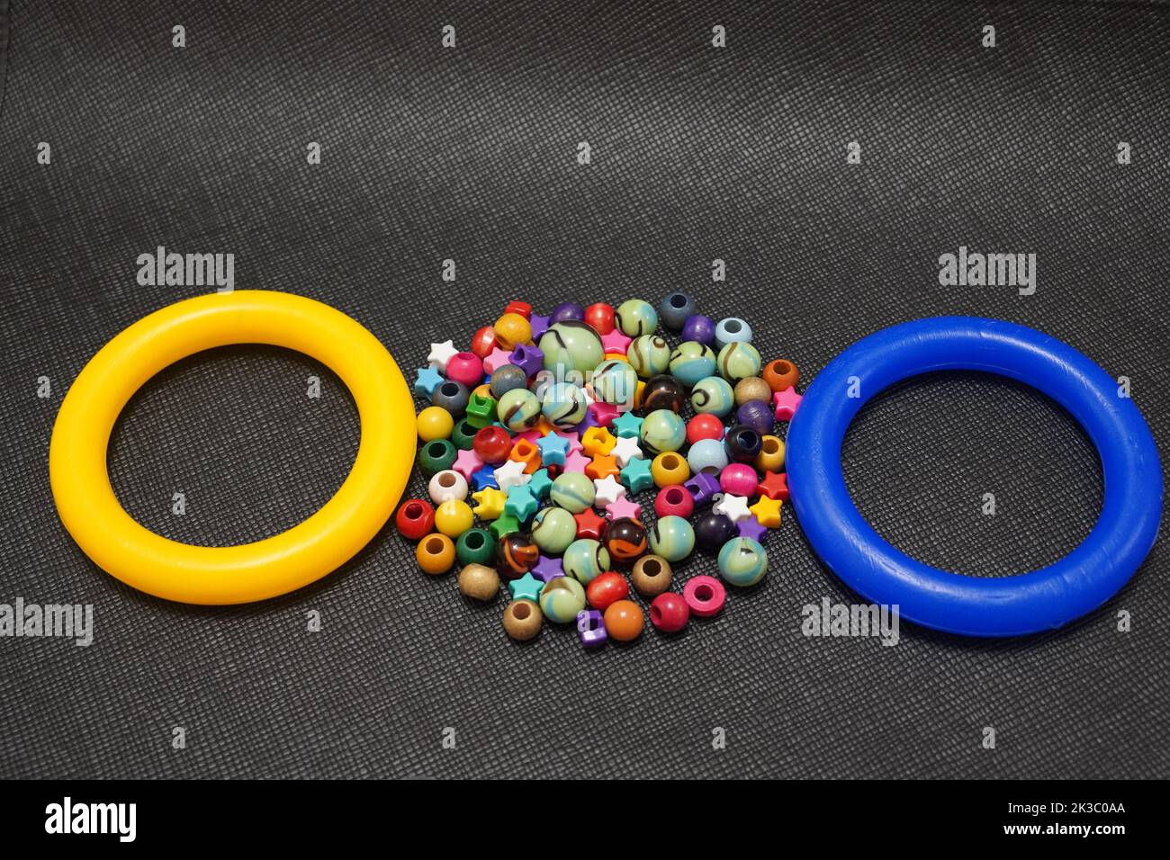 Colorful toy beads in the middle of the blue and yellow plastic ring on ...