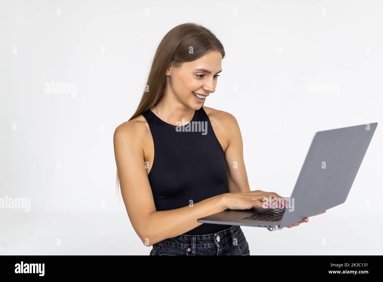 Portrait of a woman working on laptop computer isolated over white ...