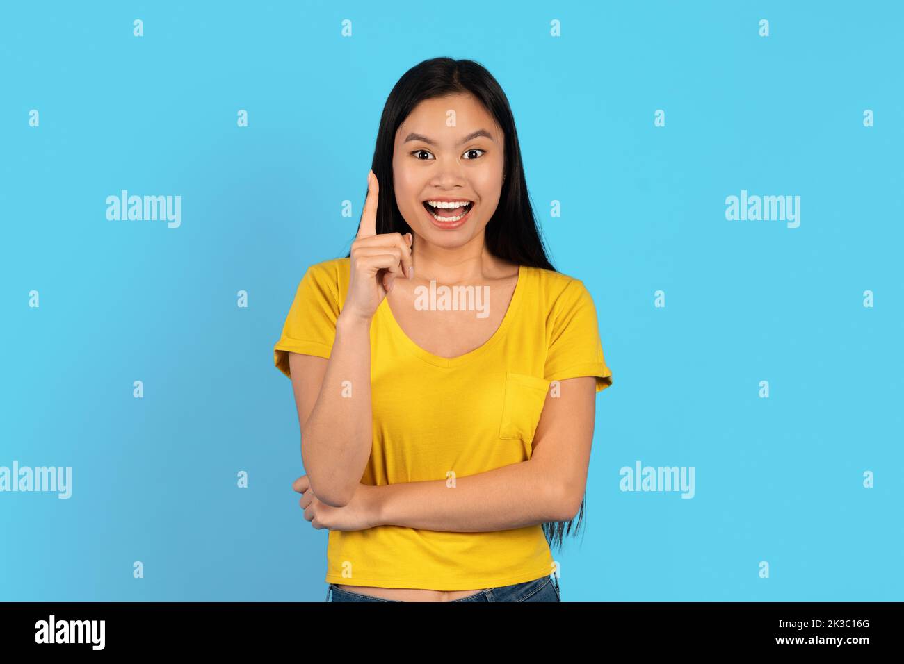 Glad inspired young japanese lady in yellow t-shirt with open mouth ...