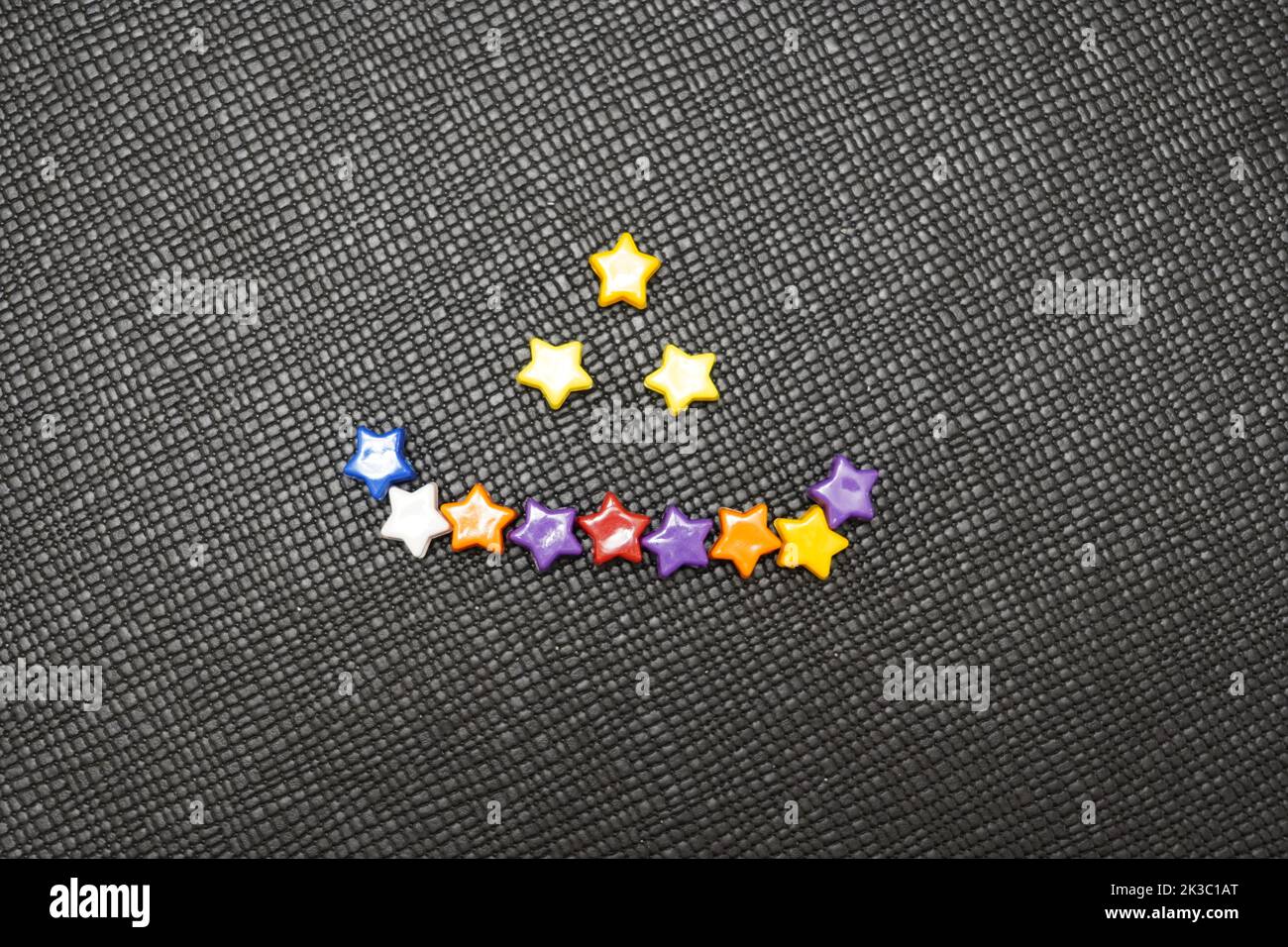 arabic lisp letter S with colorful beads in front of black textured ...