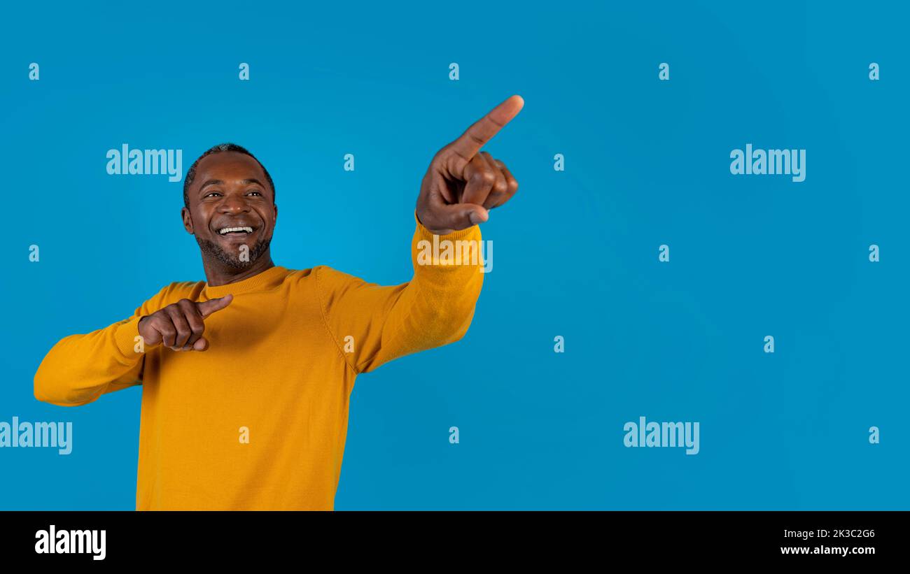 Positive african american man pointing at copy space Stock Photo - Alamy
