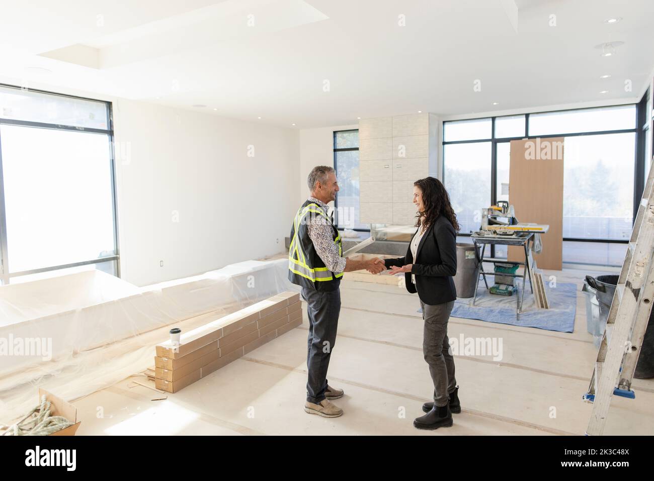 Architects shaking hands in house under construction Stock Photo - Alamy