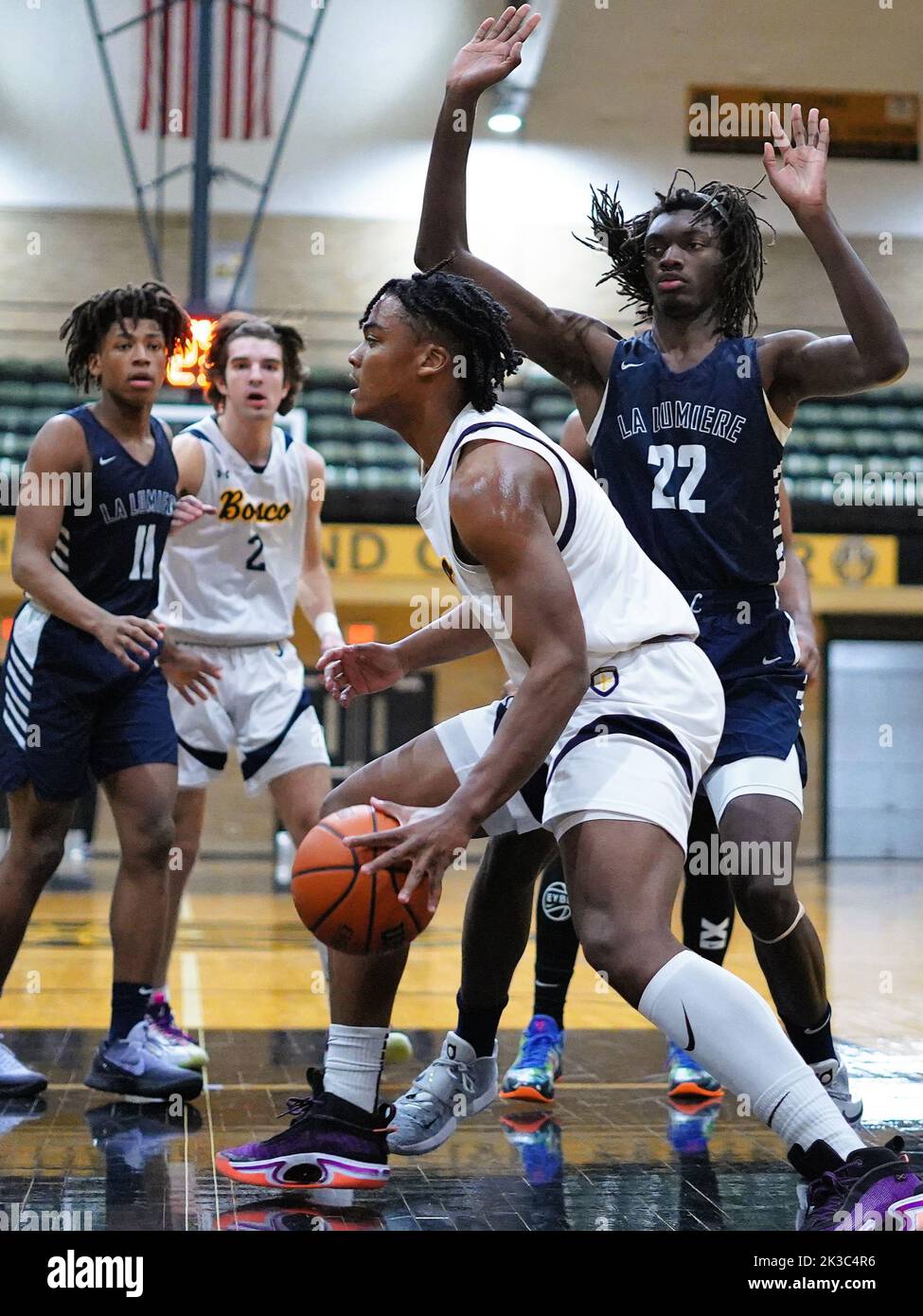 Vertical of athletic basketball players competing for the ball captured ...