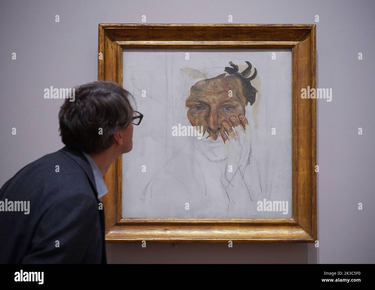 A gallery staff member poses next to a painting by Lucian Freud - Self ...