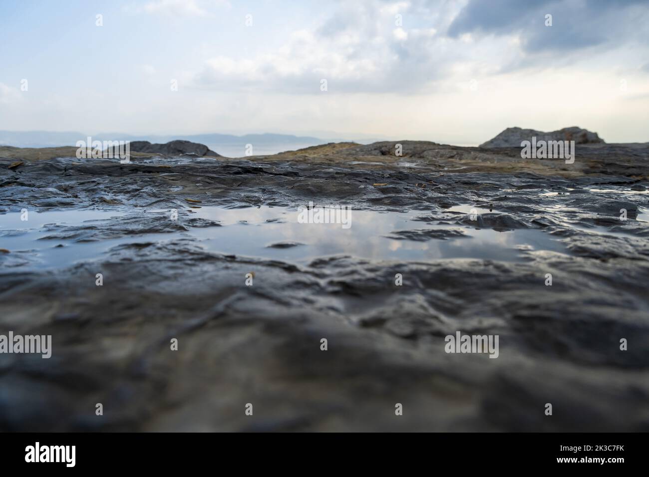 Cloud reflection in water on big stone, sea on the background ...