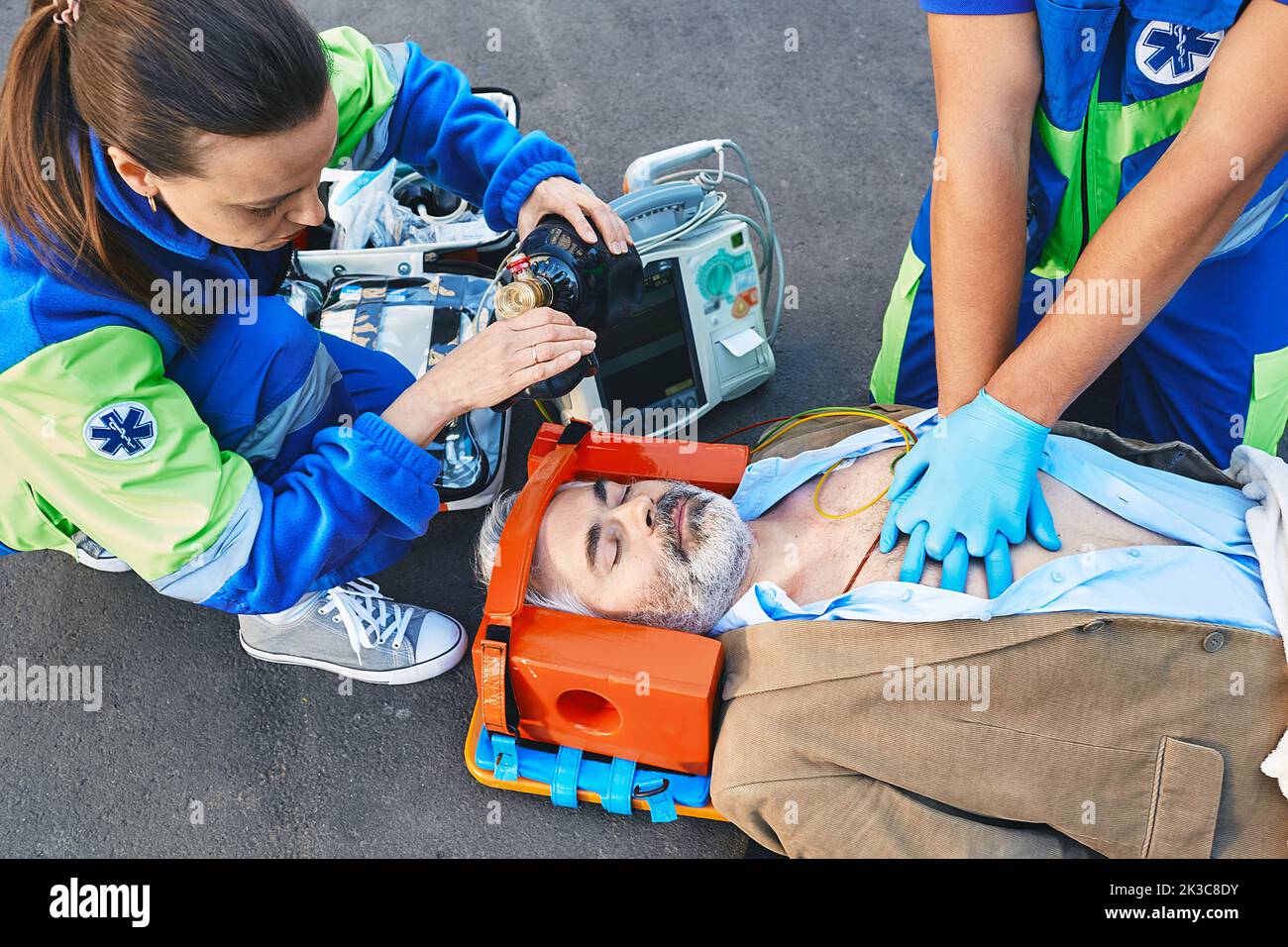First aid, ambulance. Paramedics provide first aid to injured man with medical equipment, give ...