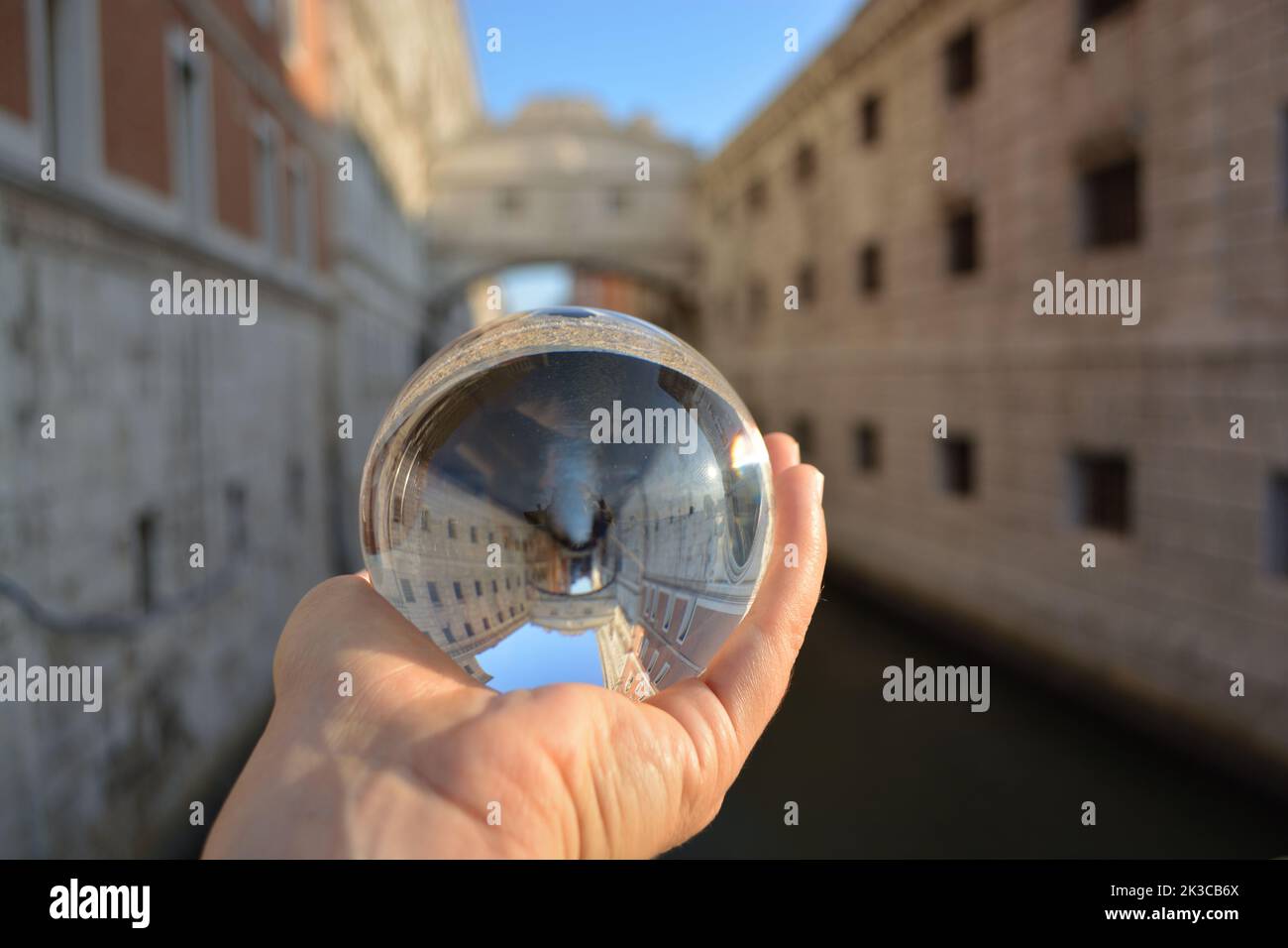 Hand holding glass sphere in front of ponte dei sospiri - bridge of ...