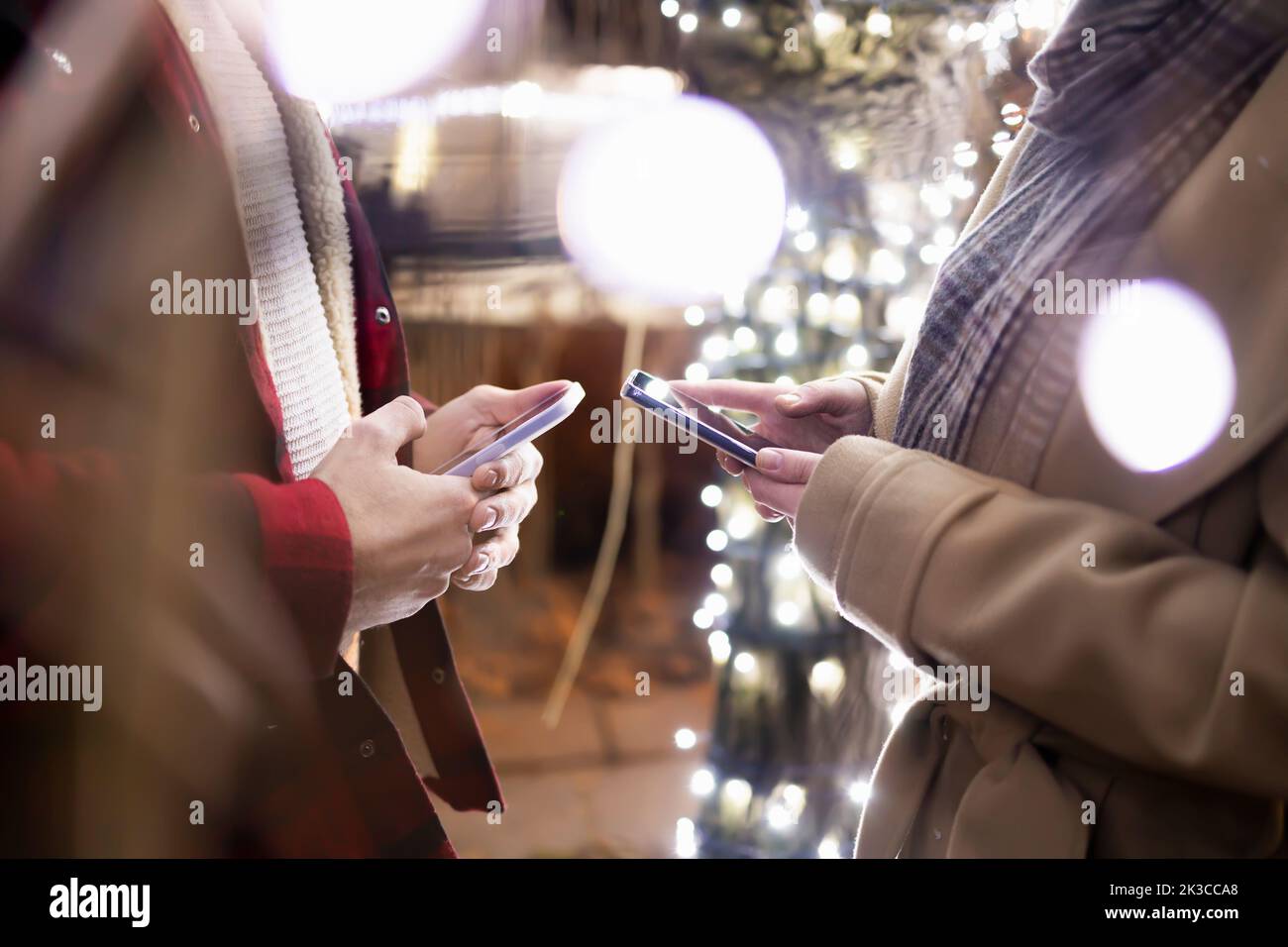 Two people using smartphones on a beautiful winter night Stock Photo ...