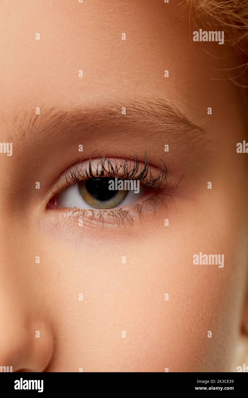 Cropped image. Closeup of little girl's eye with black curly eyelashes ...
