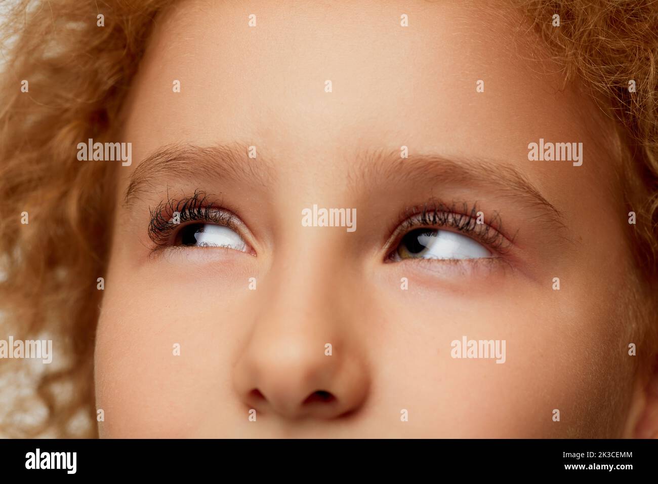 Closeup of little girl's eye with black curly eyelashes. Kids ...