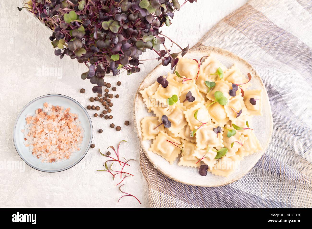 Dumplings with pepper, salt, herbs, microgreen on gray concrete ...