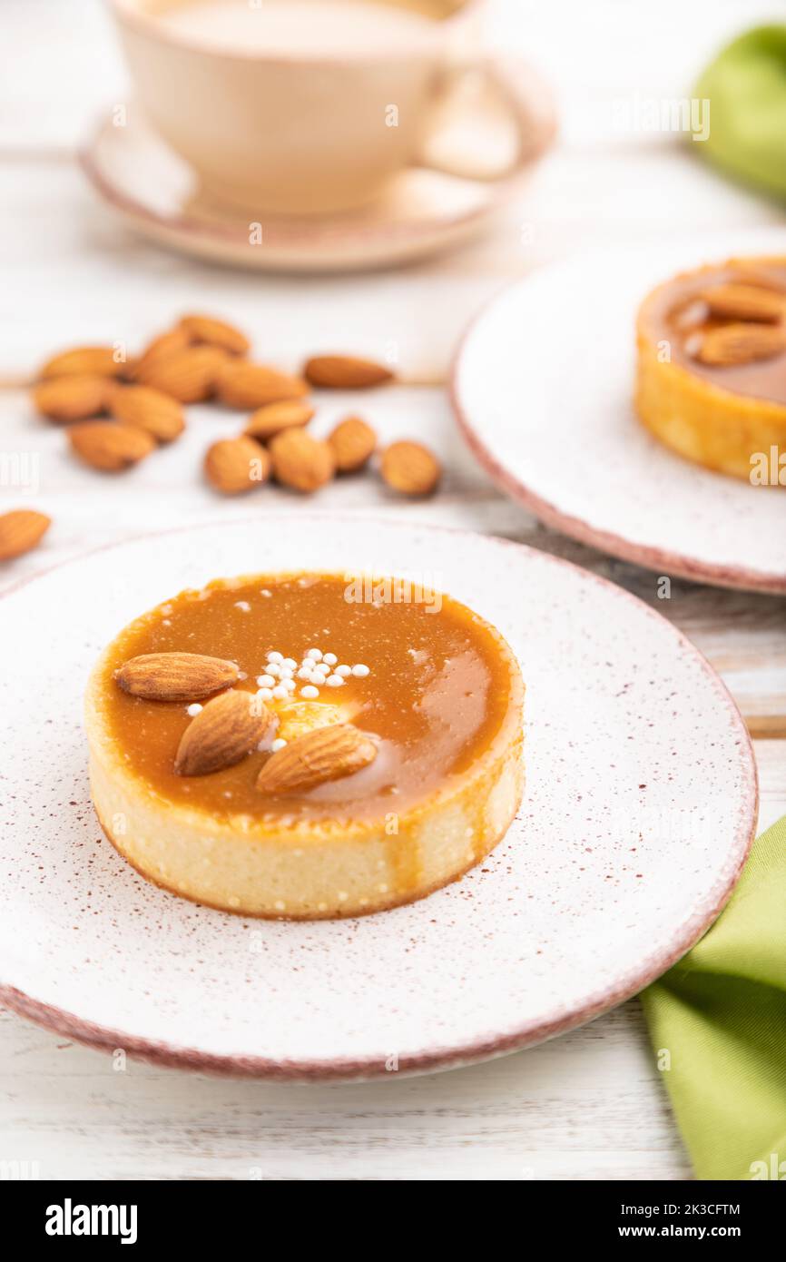 Sweet tartlets with almonds and caramel cream with cup of coffee on a ...