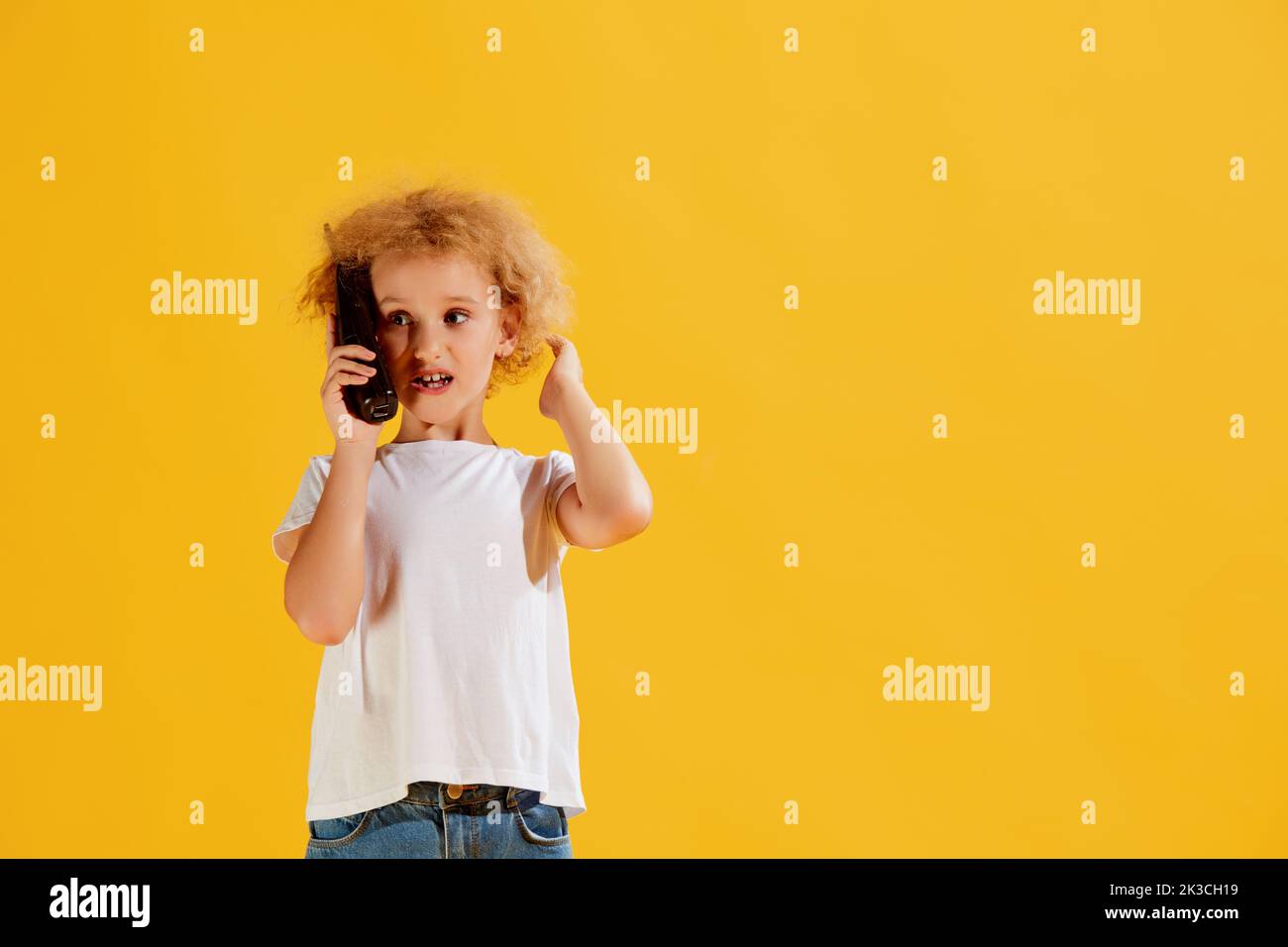 Call to past. Cute little girl, kid using retro mobile phone isolated ...