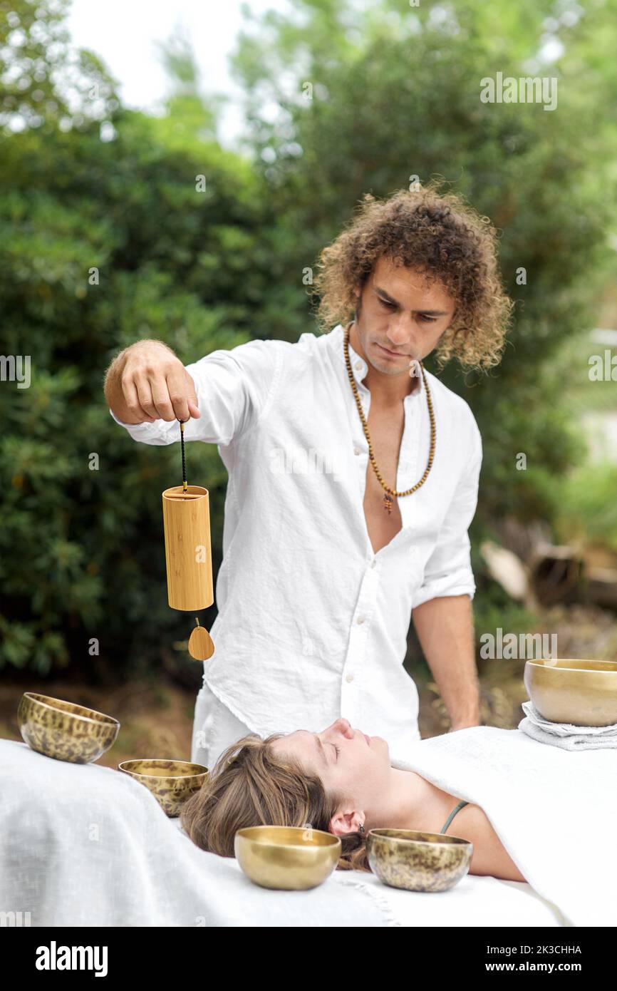 Long hair man wearing in white holding a bamboo Koshi chime musical ...