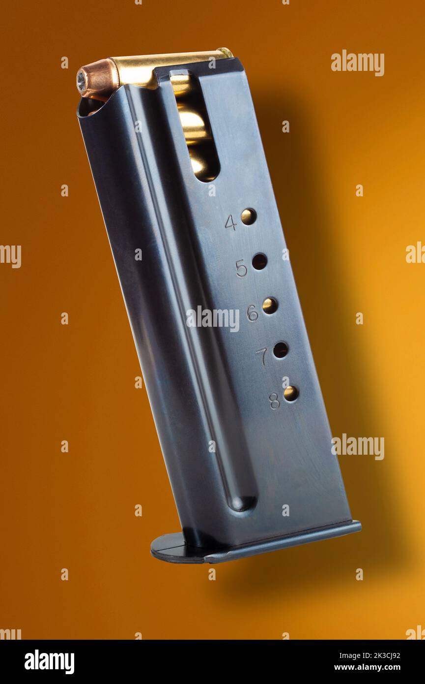 Loaded semi auto handgun magazine on an orange background with shadow ...
