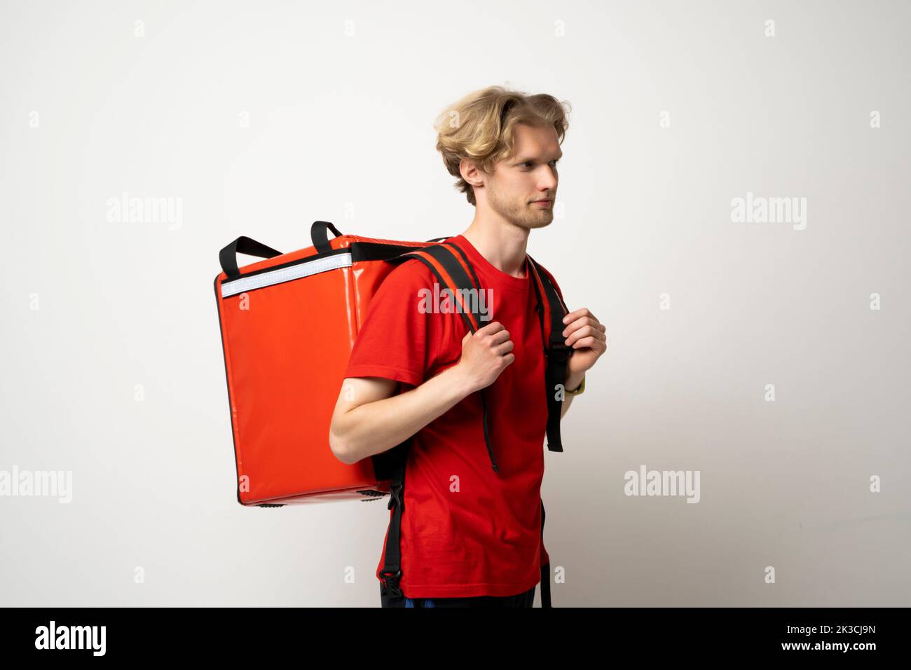 Handsome young delivery man posing with thermo backpack delivery food ...