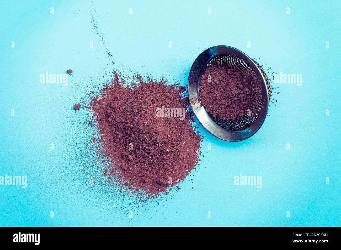 cocoa powder and pieces of chocolate on a light blue background. food ...