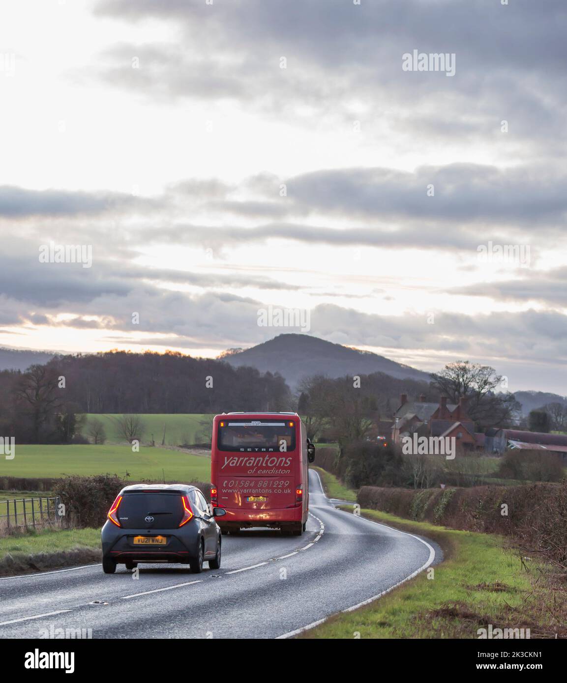 Rear view of a coach driving along a country road in Great Britain ...