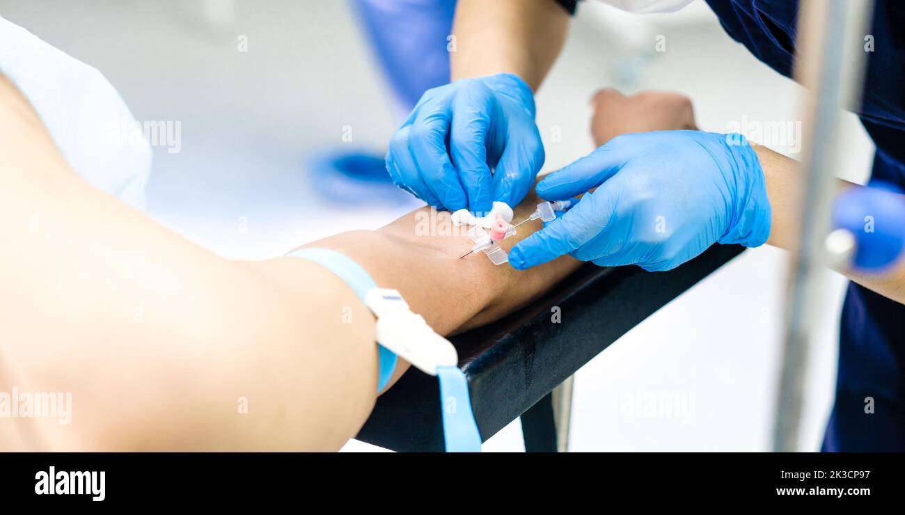 Doctor inserts dropper needle hi-res stock photography and images - Alamy
