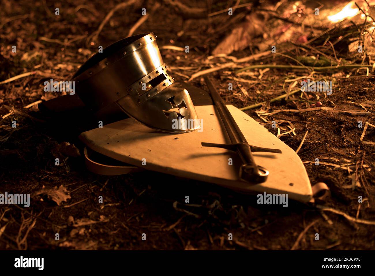 Sword, shield and helmet of a templar knight laying next to fire Stock ...