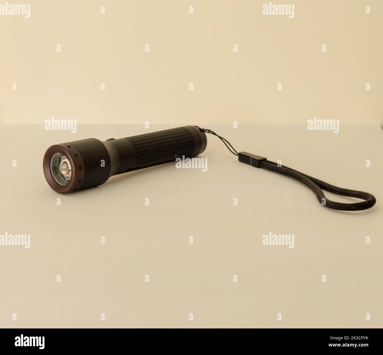 A close-up shot of a flashlight on a beige background Stock Photo - Alamy