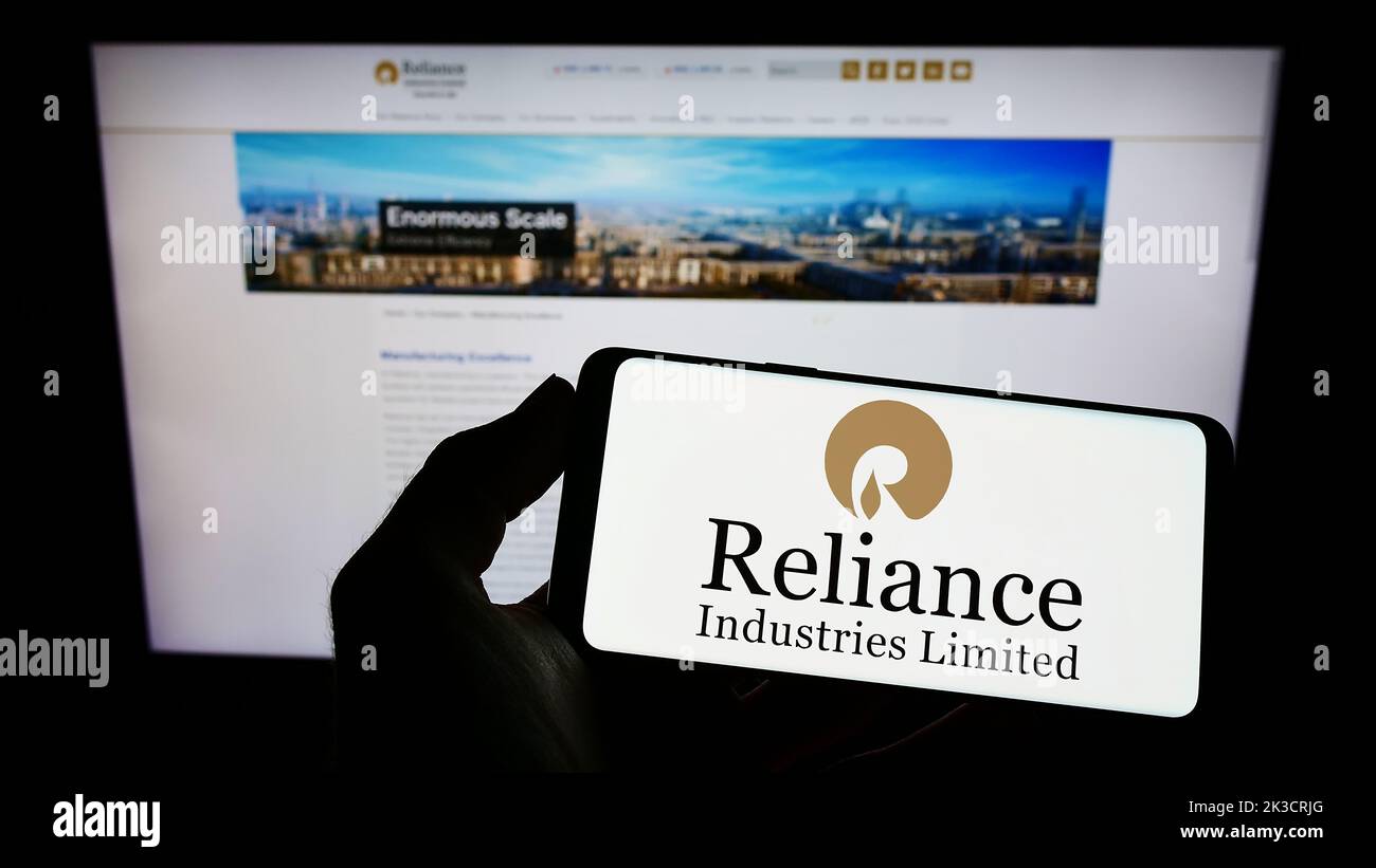 Person holding mobile phone with logo of Indian company Reliance ...