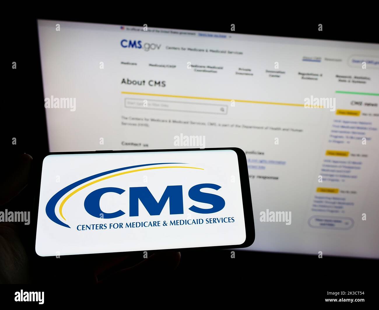 Person holding smartphone with logo of Centers for Medicare and Medicaid Services (CMS) on ...
