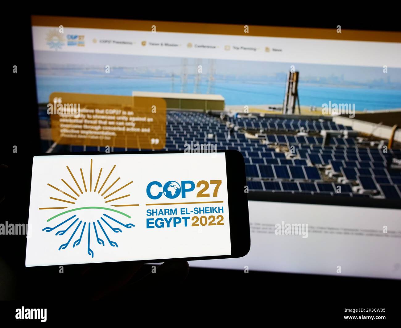 Person holding cellphone with logo of 2022 UN Climate Change Conference ...