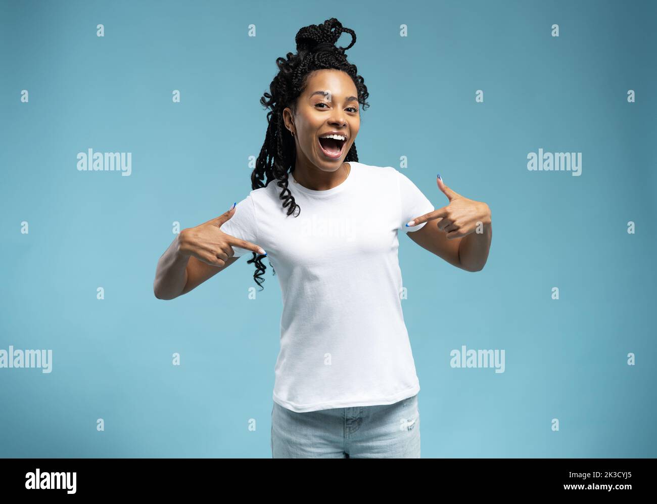Smiling African American woman wearing white t-shirt pointing finger at ...