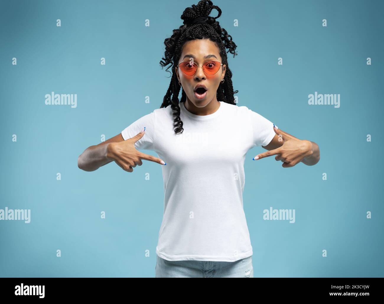 Smiling African American woman wearing white t-shirt pointing finger at ...