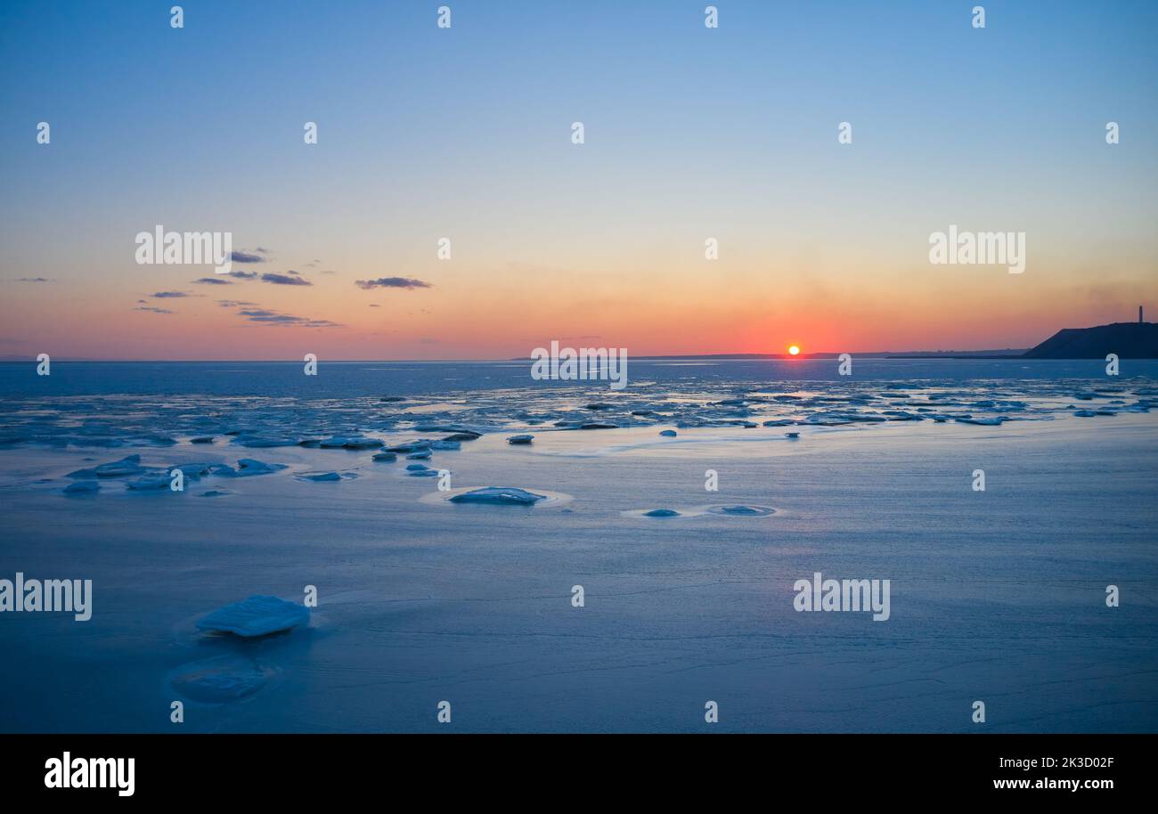 Aerial view of sunset over the frozen sea. Winter landscape on seashore ...