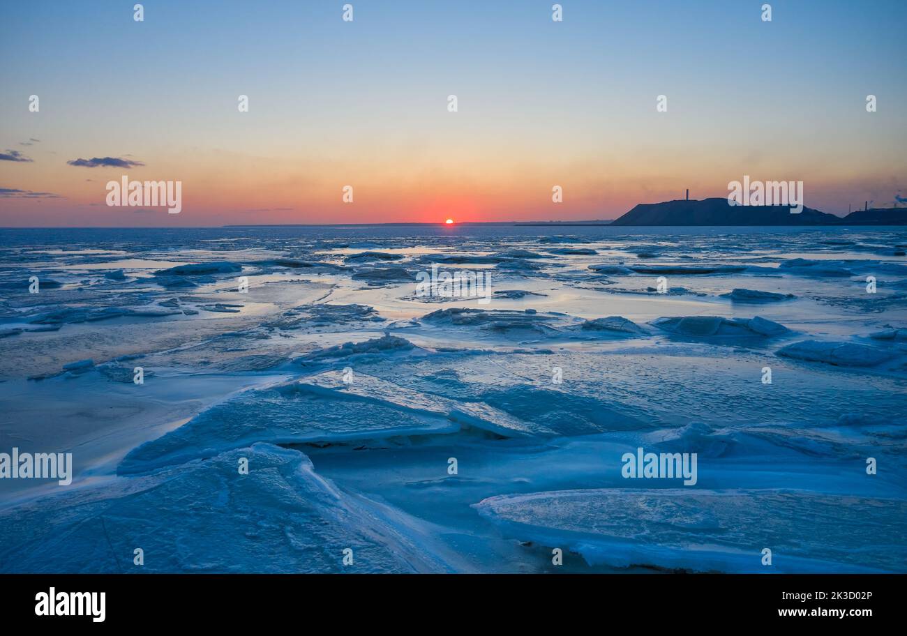 Aerial view of sunset over the frozen sea. Winter landscape on seashore ...