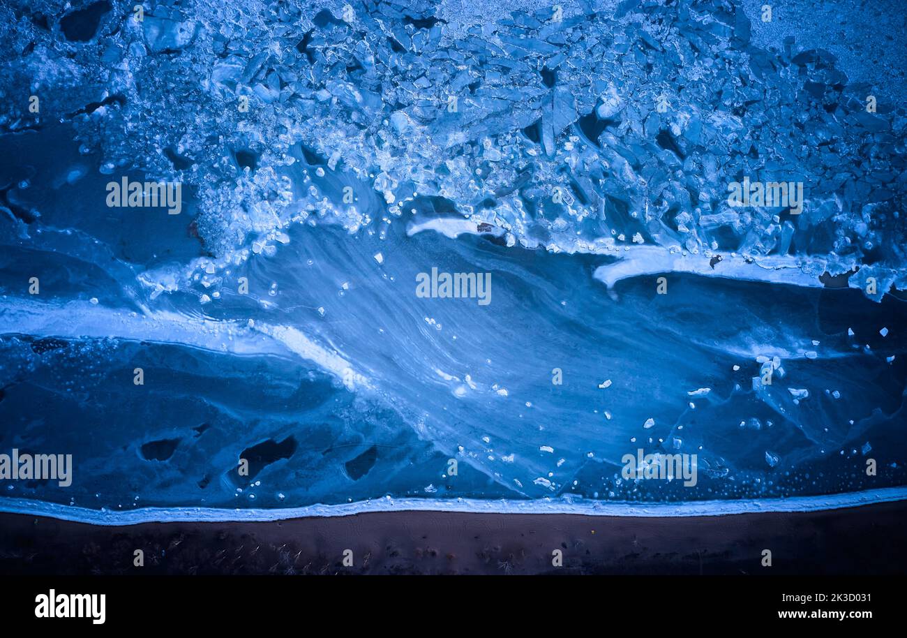 Aerial top view from above of frozen sea glaciers at the beach. Cracked ...