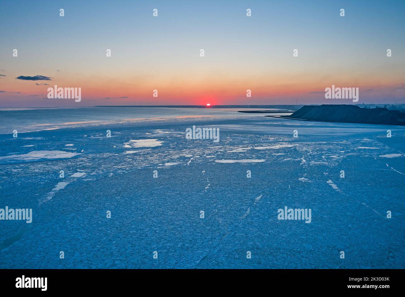 Aerial view of sunset over the frozen sea. Winter landscape on seashore ...