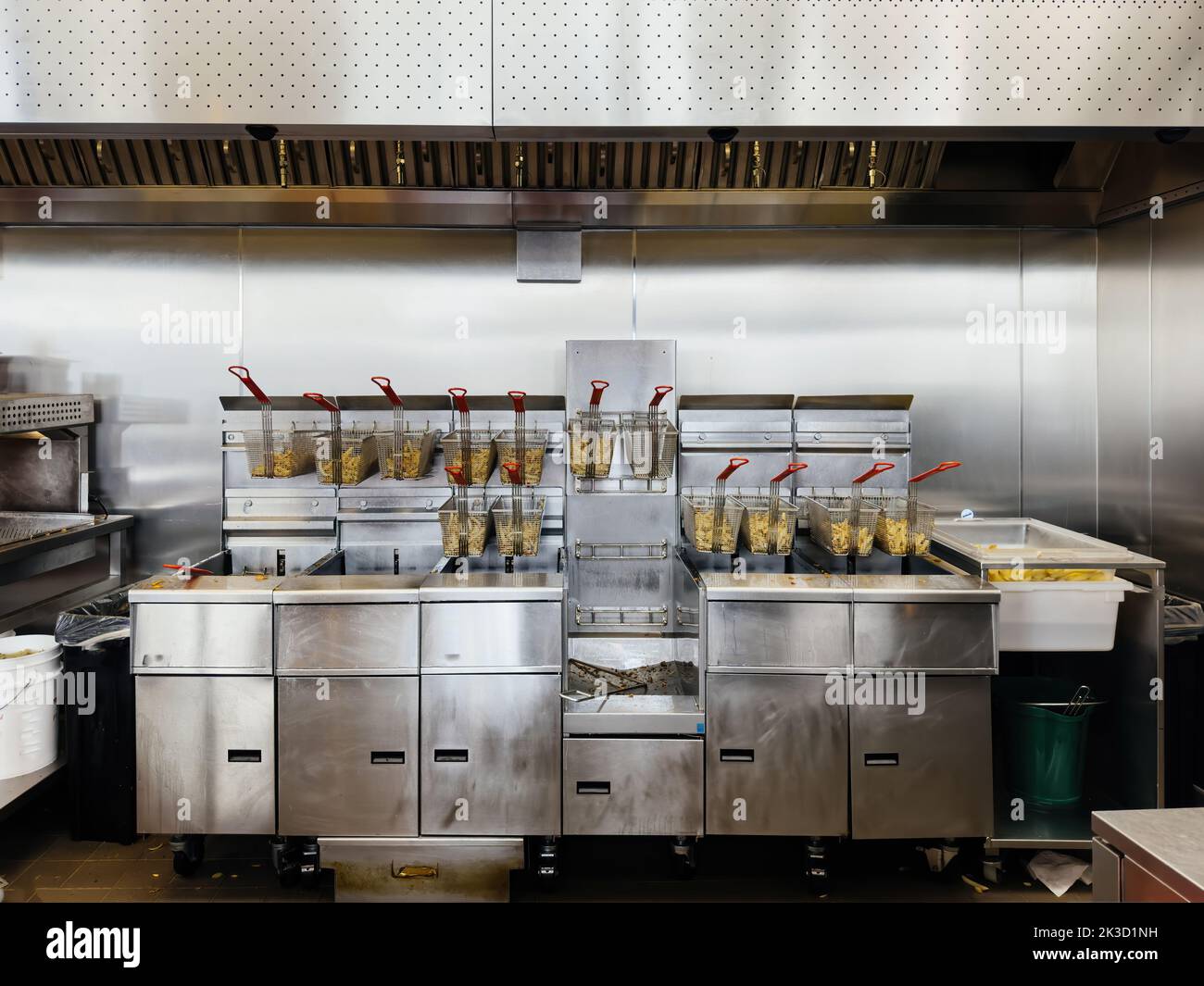 french fries cooking in multiple deep fryer mat machines inside fast ...