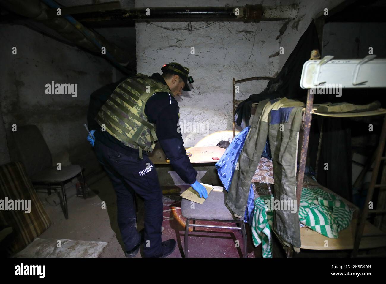 LYPTSI, UKRAINE - SEPTEMBER 24, 2022 - A police officer examines the ...