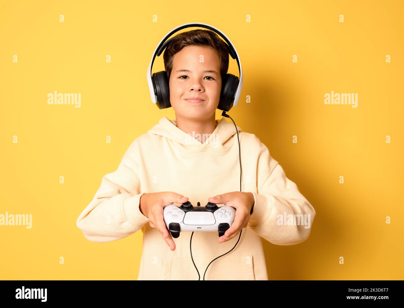 A young child having fun playing video games standing isolated over ...