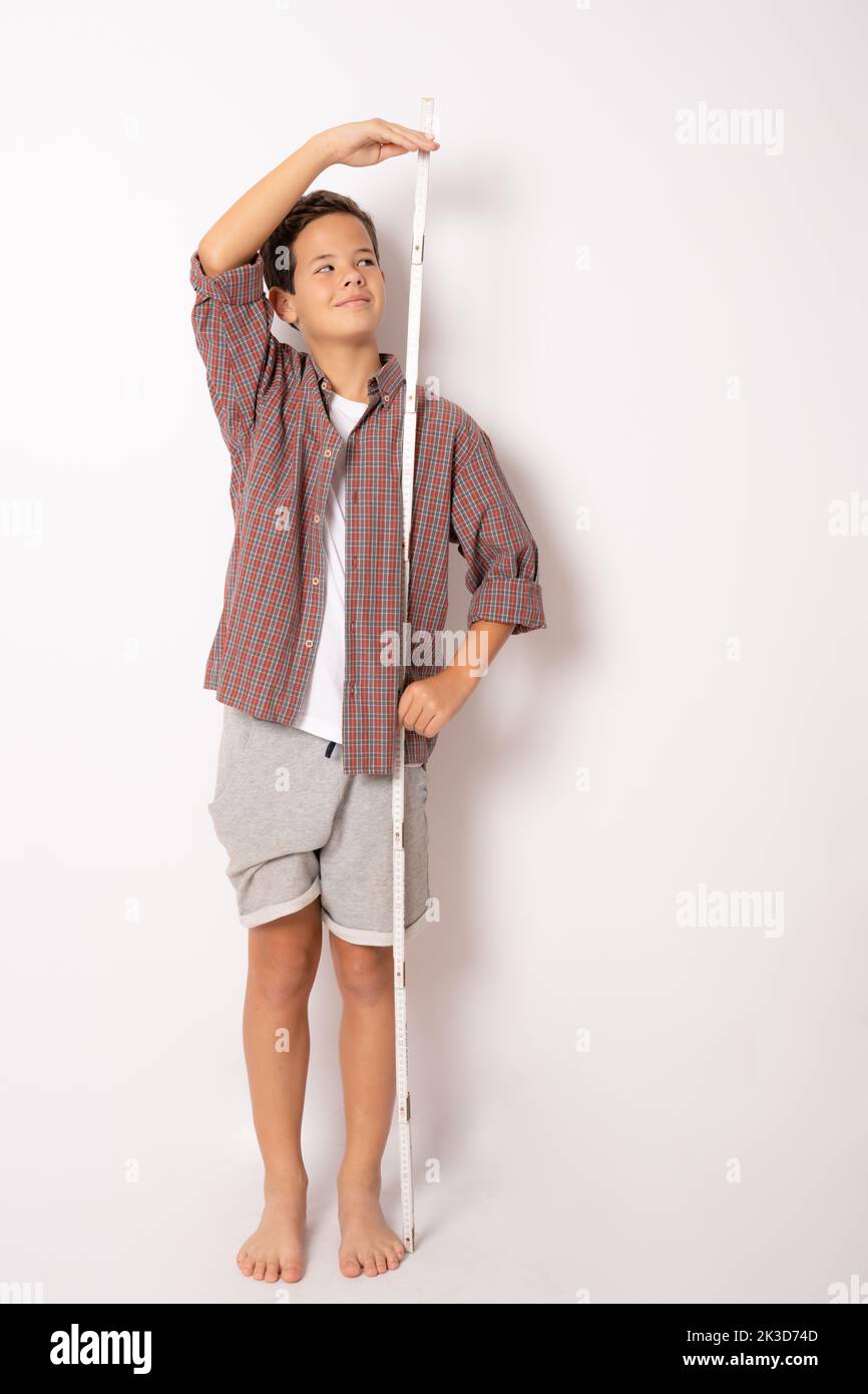 Happy boy measuring his own height - isolated on white Stock Photo - Alamy
