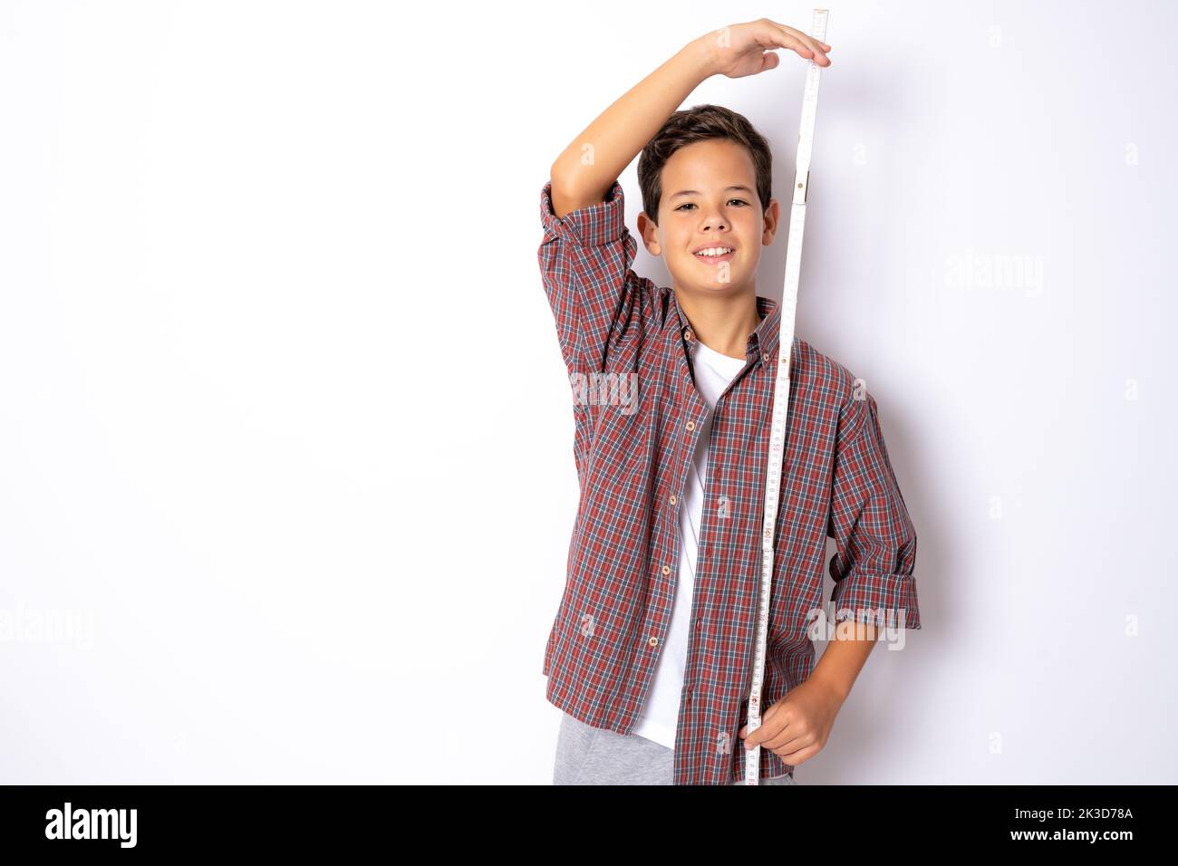 Happy boy measuring his own height - isolated on white Stock Photo - Alamy