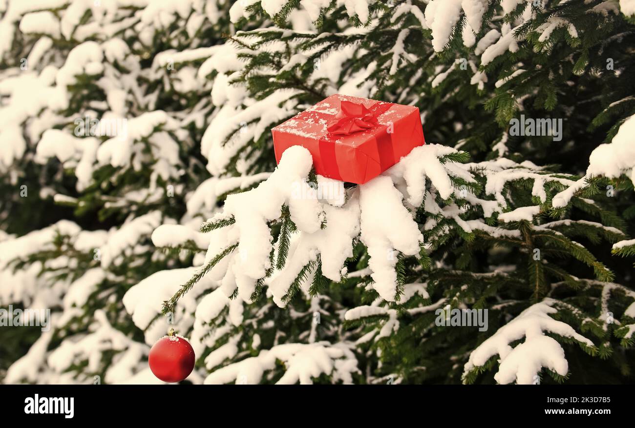 Christmas eve. Shopping. Kindness and generosity. Red gift box on snowy ...