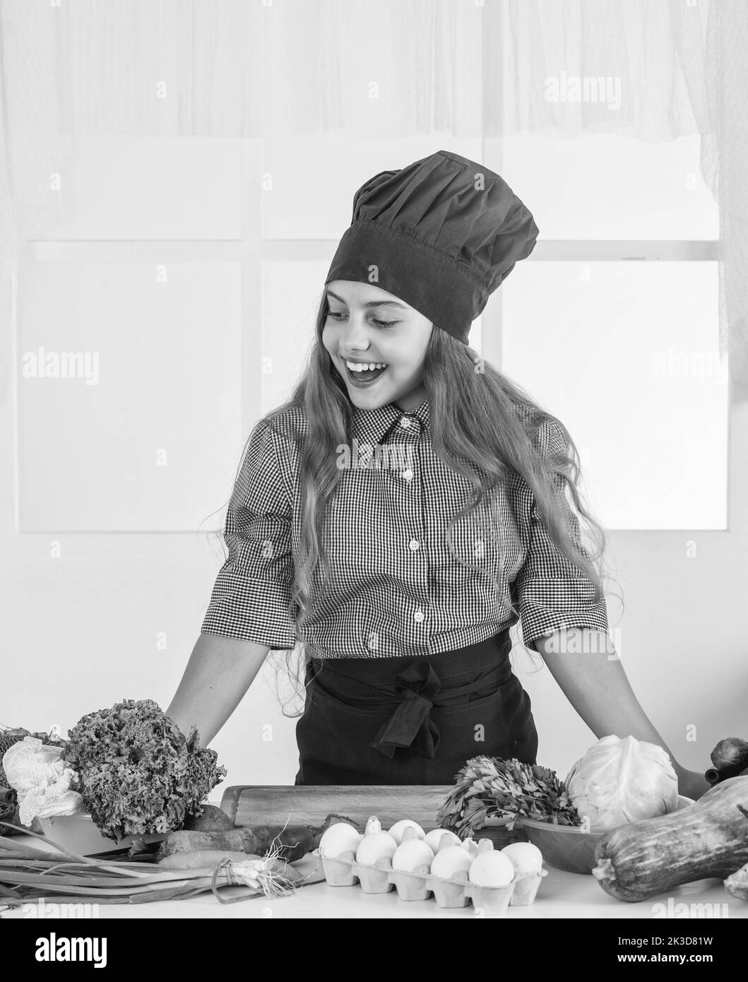 happy teen girl cooking vegetables. kid wearing professional chef ...