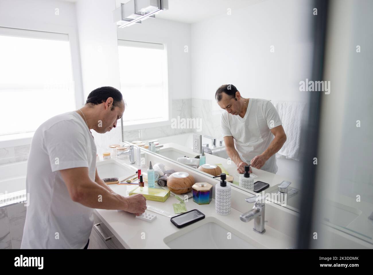Man taking Covid rapid antigen test in bathroom Stock Photo - Alamy