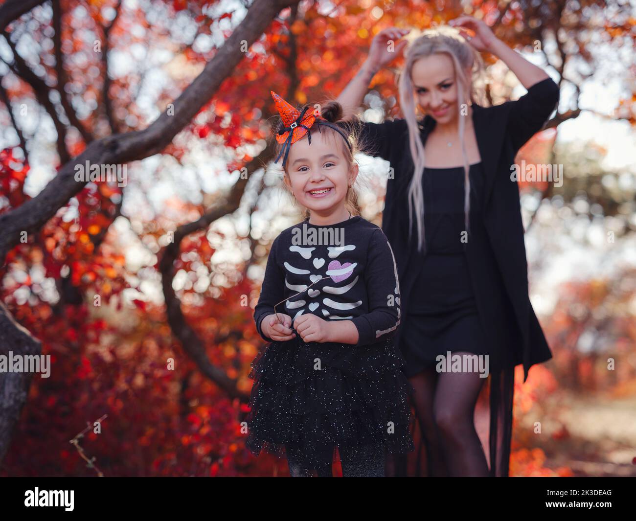 Mother and her child girl playing together. goes trick or treating ...