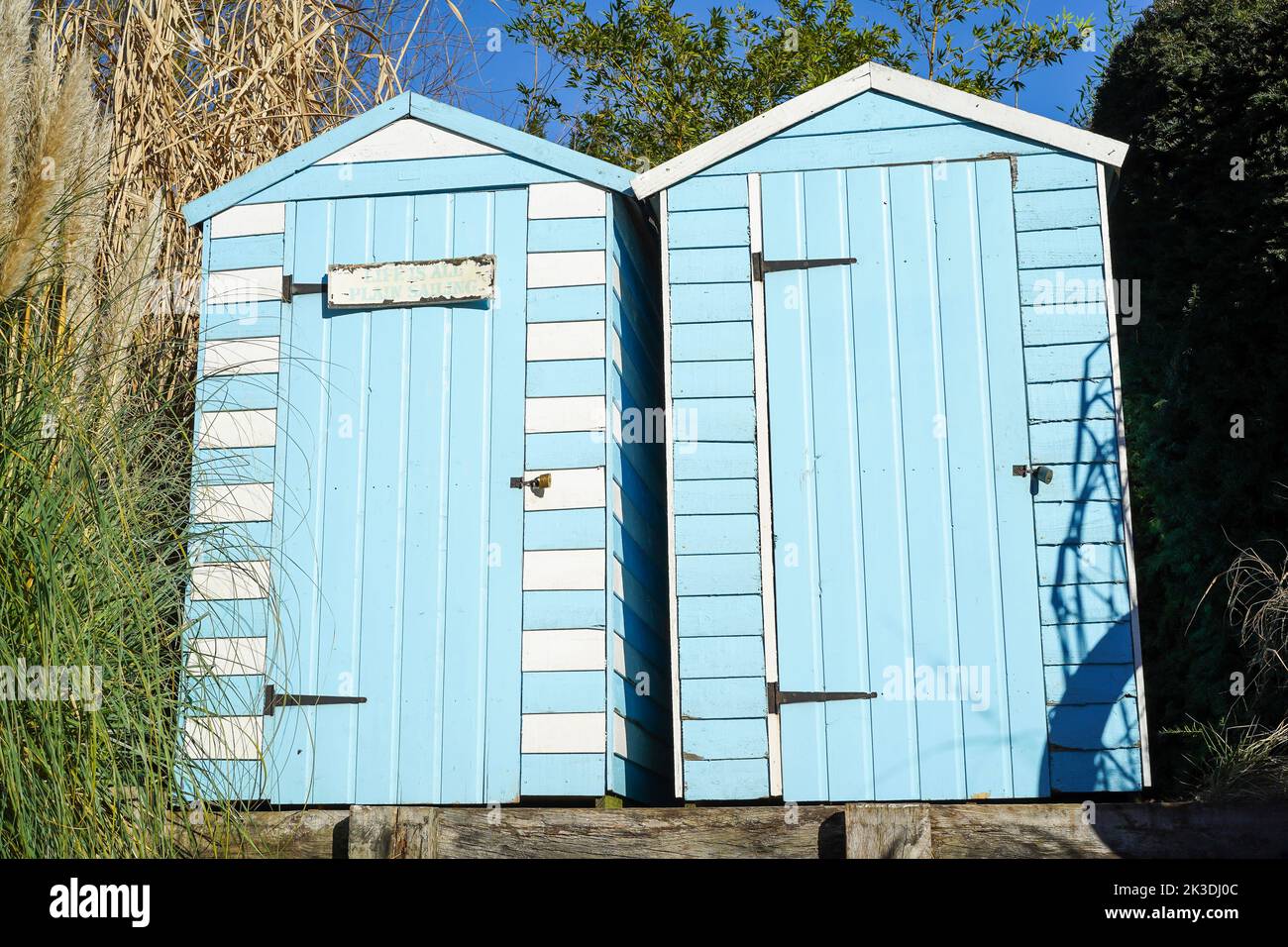 Two blue and white small sheds. Sign on left shed says "life is all ...