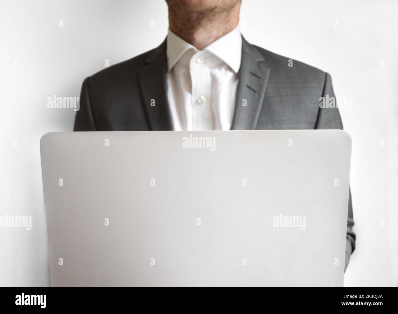Businessman behind a laptop computer against white background Stock ...